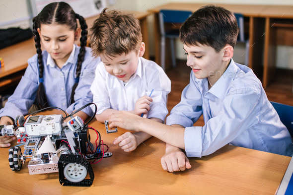 Kids playing with electrical robot while visiting robotics exhibition ...