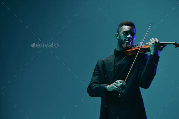 Elegant musician in formal attire playing the violin skillfully against ...