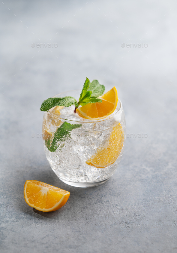 Lemonade tonic drink with fresh lemon, mint and ice on a light ...