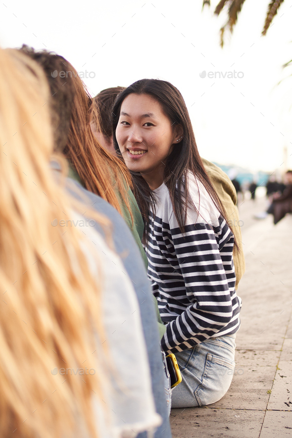 Portrait of happy young Chinese girl looking at smiling camera with ...