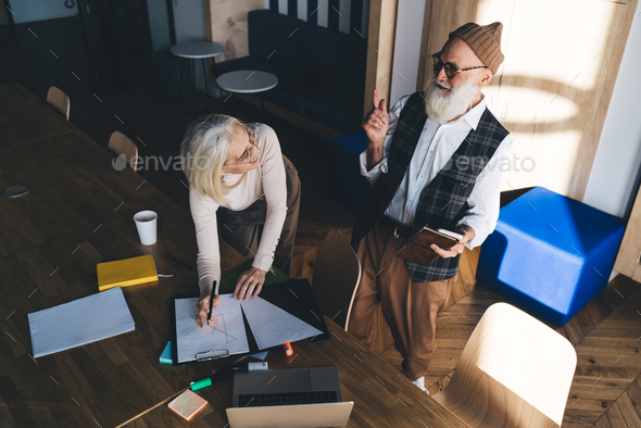 Senior colleagues at table and working on business Stock Photo by GaudiLab