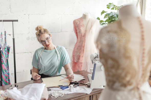 Fashion designer at work. Talanted dressmaker drawing sketch at her ...