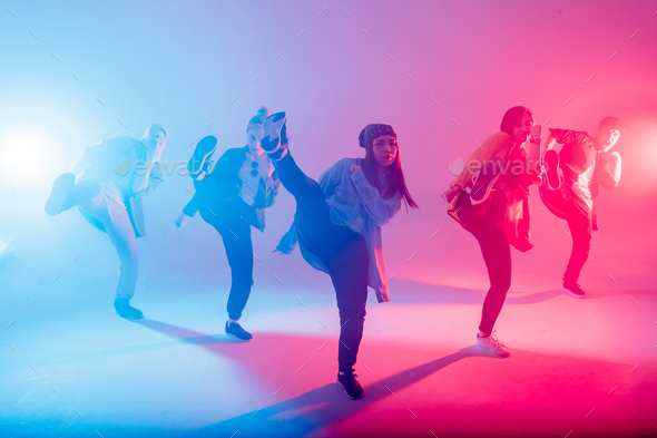 Group of diverse young hip-hop dancers in studio with special lighting ...