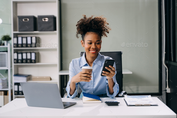 Confident woman with a smile standing holding notepad and tablet at the ...