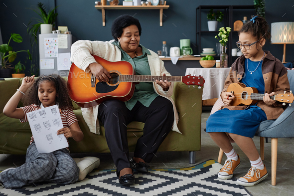 Senior Woman with Two Girls Playing Musical Instruments Stock Photo by ...
