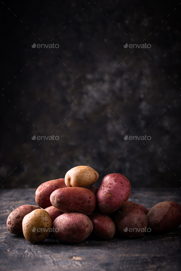 Raw uncooked potato on dark table Stock Photo by furmanphoto | PhotoDune