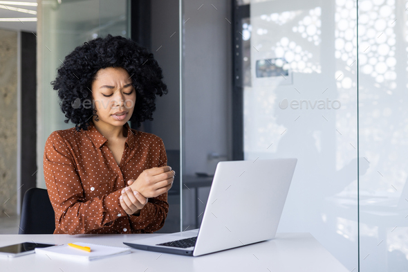 Young businesswoman feeling wrist pain at her office desk Stock Photo ...