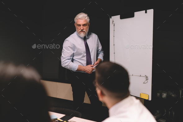 Male boss explaining chart for employees Stock Photo by GaudiLab ...
