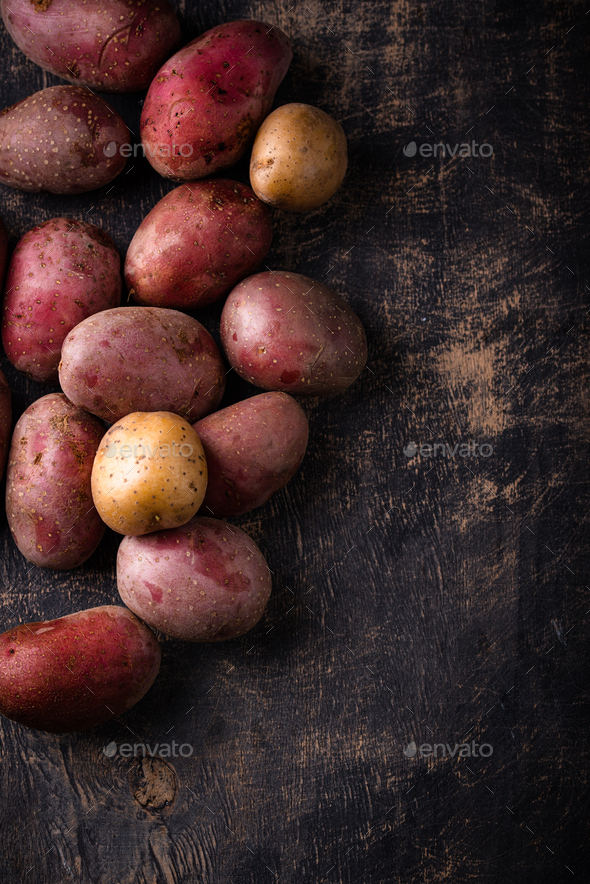 Raw uncooked potato on dark table Stock Photo by furmanphoto | PhotoDune
