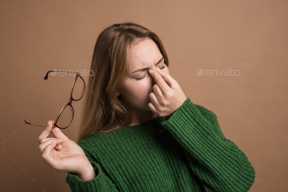 woman with poor vision on a isolated beige background, health problems ...