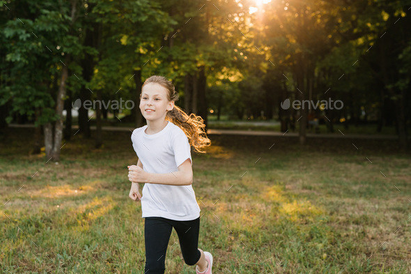 Excited child girl athlete running in the park. Sport, physical ...