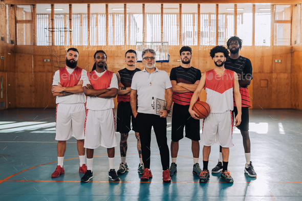 Portrait of a diverse basketball team and their coach standing on a ...