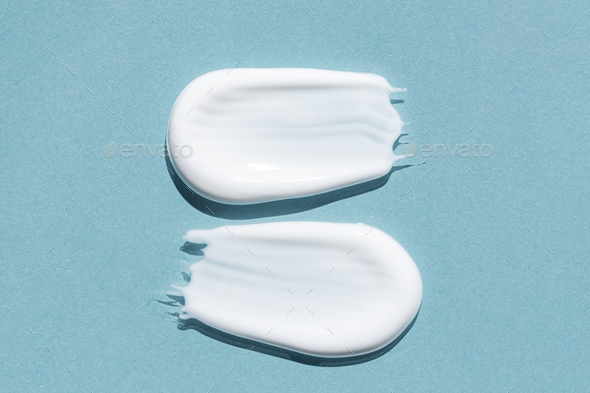 Cosmetic product smear white moisturizing lotion isolated on blue ...