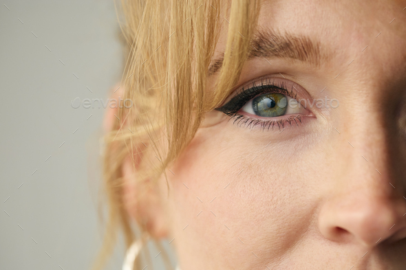 Close Up Studio Shot Of Woman's Eye Looking At Camera Against Plain ...