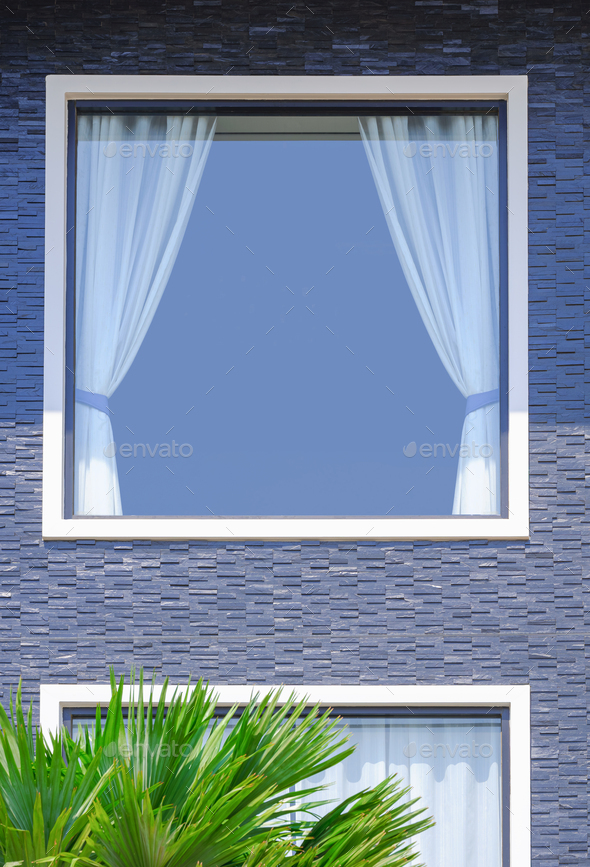 2 square glass windows with curtain on gray stone slate tile wall of ...