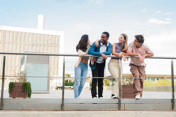 Full length portrait of four teenage real students smiling and talking ...