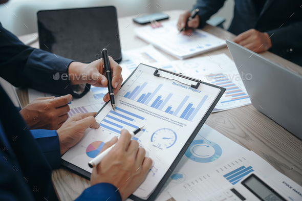 Professional business team meeting in formal suits, working at desks ...