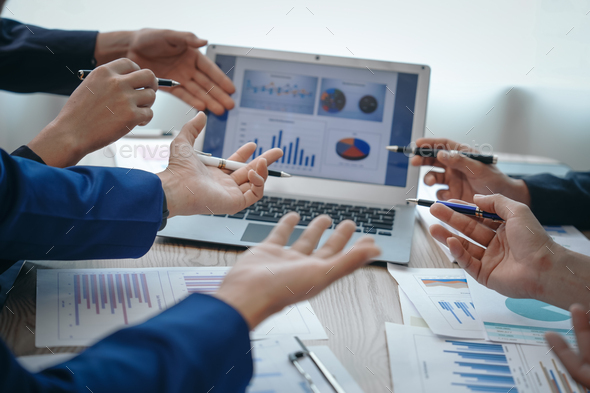 Professional business team meeting in formal suits, working at desks ...