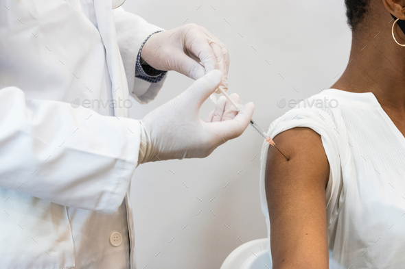 Doctor making injection for black woman patient Stock Photo by ADDICTIVE_STOCK
