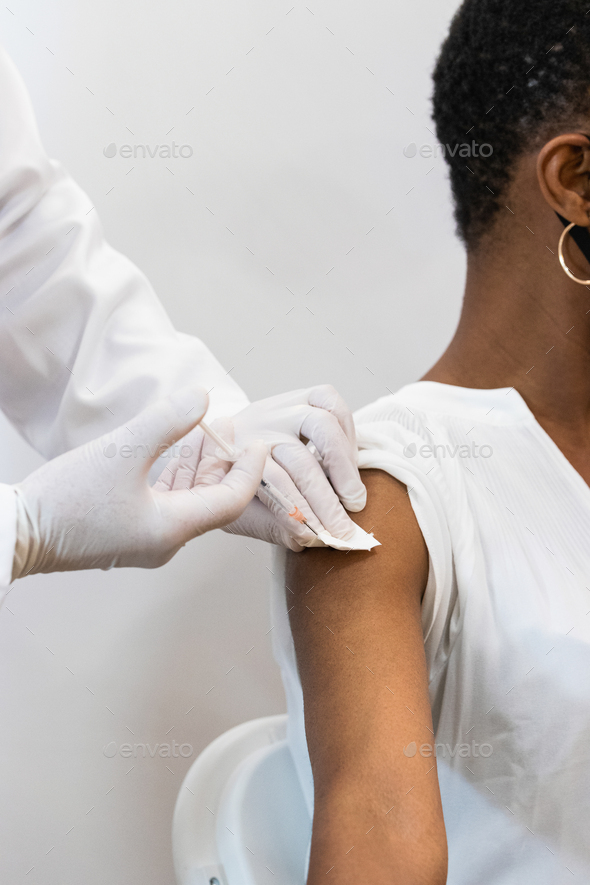 Doctor making injection for black woman patient Stock Photo by ADDICTIVE_STOCK