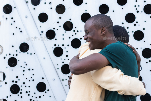 Black male friends hugging happily at meeting Stock Photo by ADDICTIVE ...