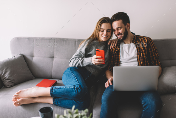 Positive couple browsing gadgets together Stock Photo by GaudiLab ...