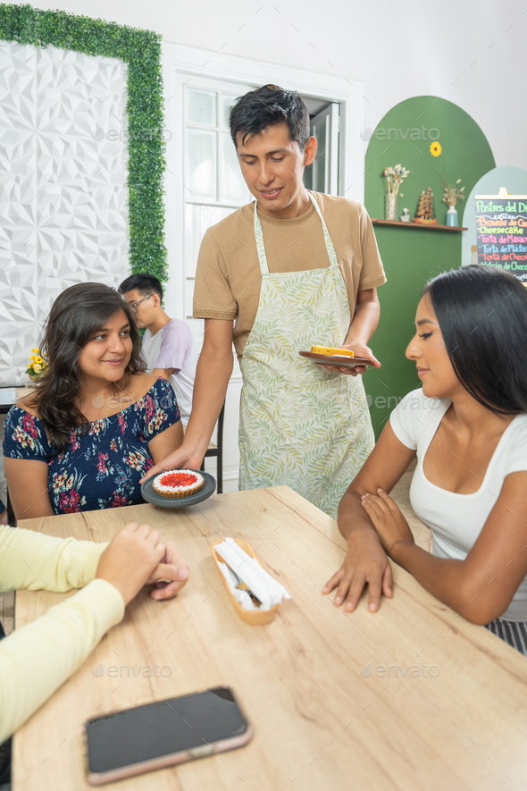 Waiter bringing the desserts to the table of the diners Stock Photo by ...