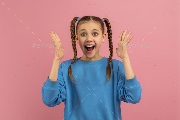 Excited Young Girl With Braided Hair Celebrating Surprise on Pink Stock ...