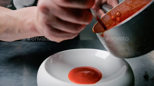 Chef Pouring Tomato Sauce For Plating Stock Photo by francescosgura