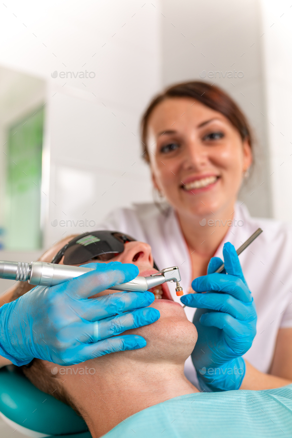Treatment of caries. A dentist treats the patient's teeth for pulpitis ...