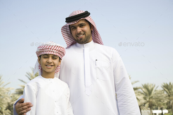 Smiling father and son wearing traditional Arabic attire outdoors Stock ...