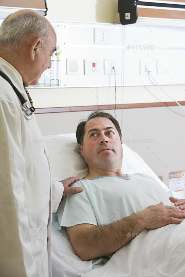 Doctor comforting patient in hospital bed Stock Photo by Image-Source