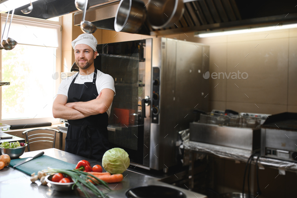 Chef cook in uniform cooking in the big cooker at the restaurant ...