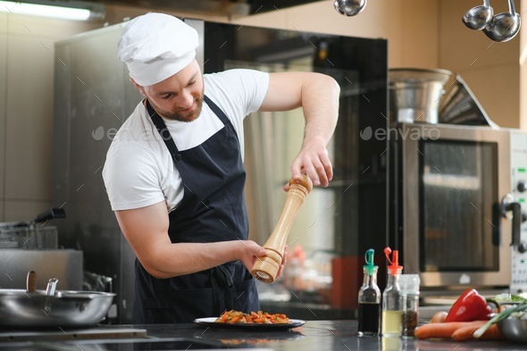Chef cook in uniform cooking in the big cooker at the restaurant ...
