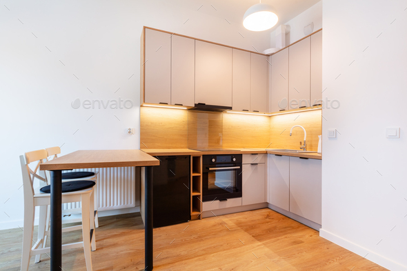 Well-lit kitchen area with wooden fixtures and modern design Stock ...