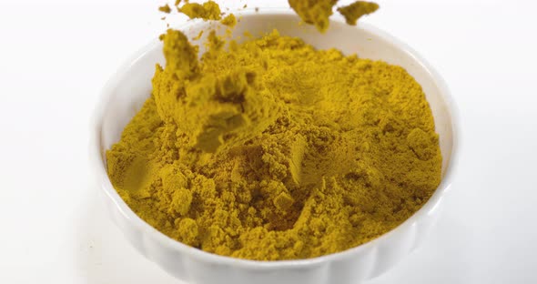 Curry Powder falling into a Bowl against White Background, Slow motion ...