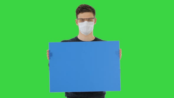 Young Man in Medical Mask Showing and Displaying Placard on a Green ...