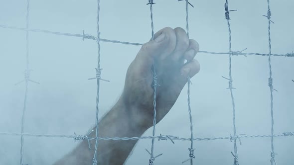 Hand On Prison Wire With Passing Smoke, Stock Footage | VideoHive