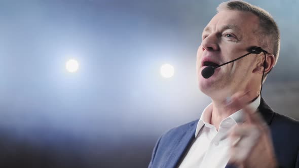 Portrait of Men Speaking Through a Microphone in Dark Conference Hall ...