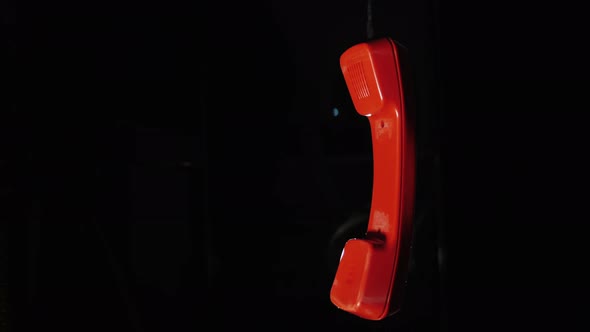 Red Telephone Receiver From a Retro Phone Hanging on a Wire on a Black ...