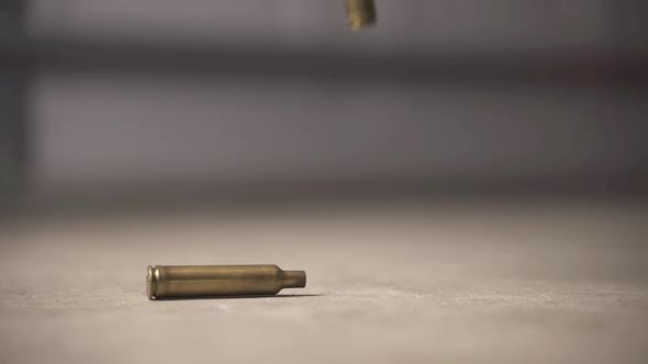308 bullet shells falling to the ground in slow motion., Stock Footage
