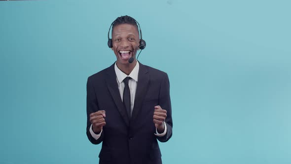 Black male cameraman in a suit and headset emotionally rejoices ...