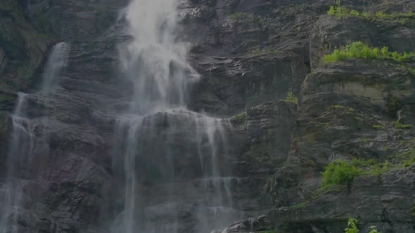 Spectacular waterfall spraying water drizzle drops on rock,tilt down ...