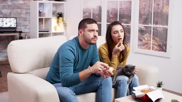 Couple Sitting on Sofa Eating Fried Chicken, Stock Footage | VideoHive