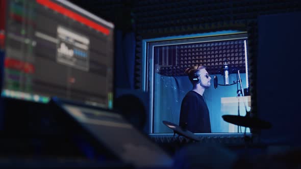 Male Rap Singer with Headphones and Sound Engineer Are Recording a New ...