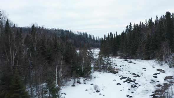 Aerial, person sightseeing on bridge over frozen Poplar River in Lutsen ...