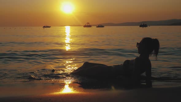 Beautiful Young Girl Lying on the Beach at Sunset. Girl on Vacation ...