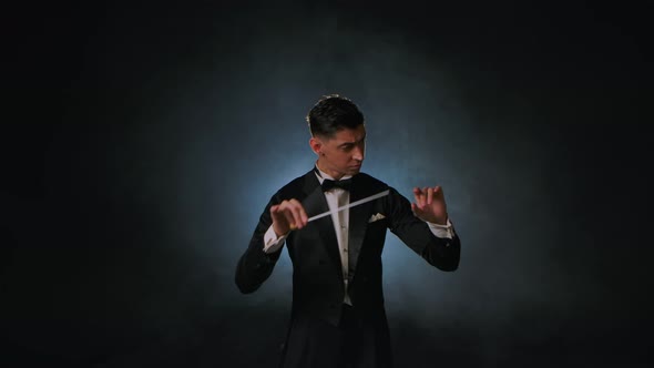 An Orchestra Leader Wearing Suit Using the Conducting Baton to ...