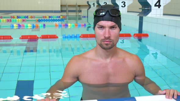 A Professional Swimmer Looks Seriously at the Camera at the Edge of an ...