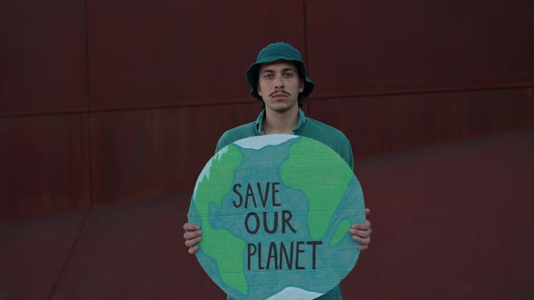 Young Man Posing on Street with Save Our Planet Banner, Stock Footage